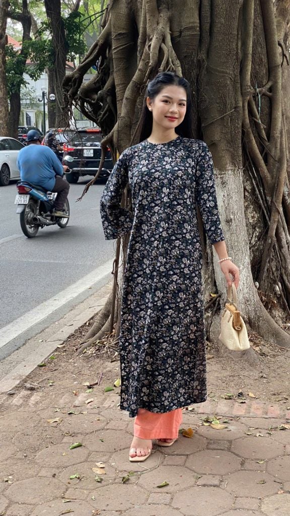 Áo dài cổ tròn dáng suông thô lụa nền đen họa tiết hoa lá.